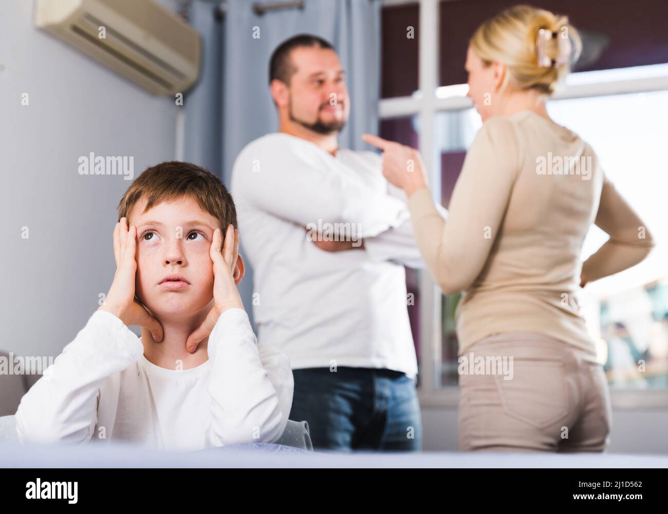 Upset son suffering from parents arguing Stock Photo - Alamy