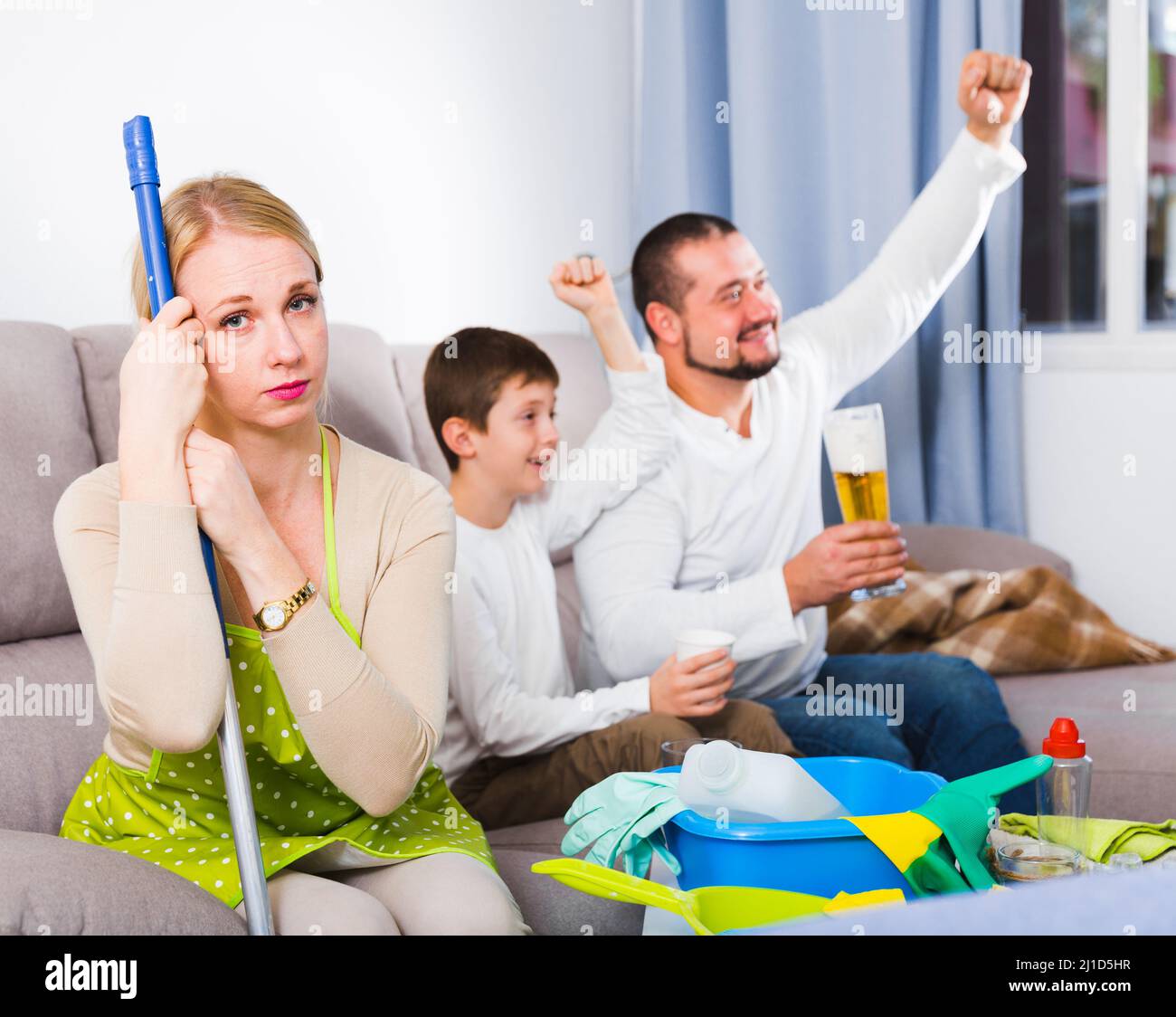 Upset woman with cleaning equipment Stock Photo - Alamy
