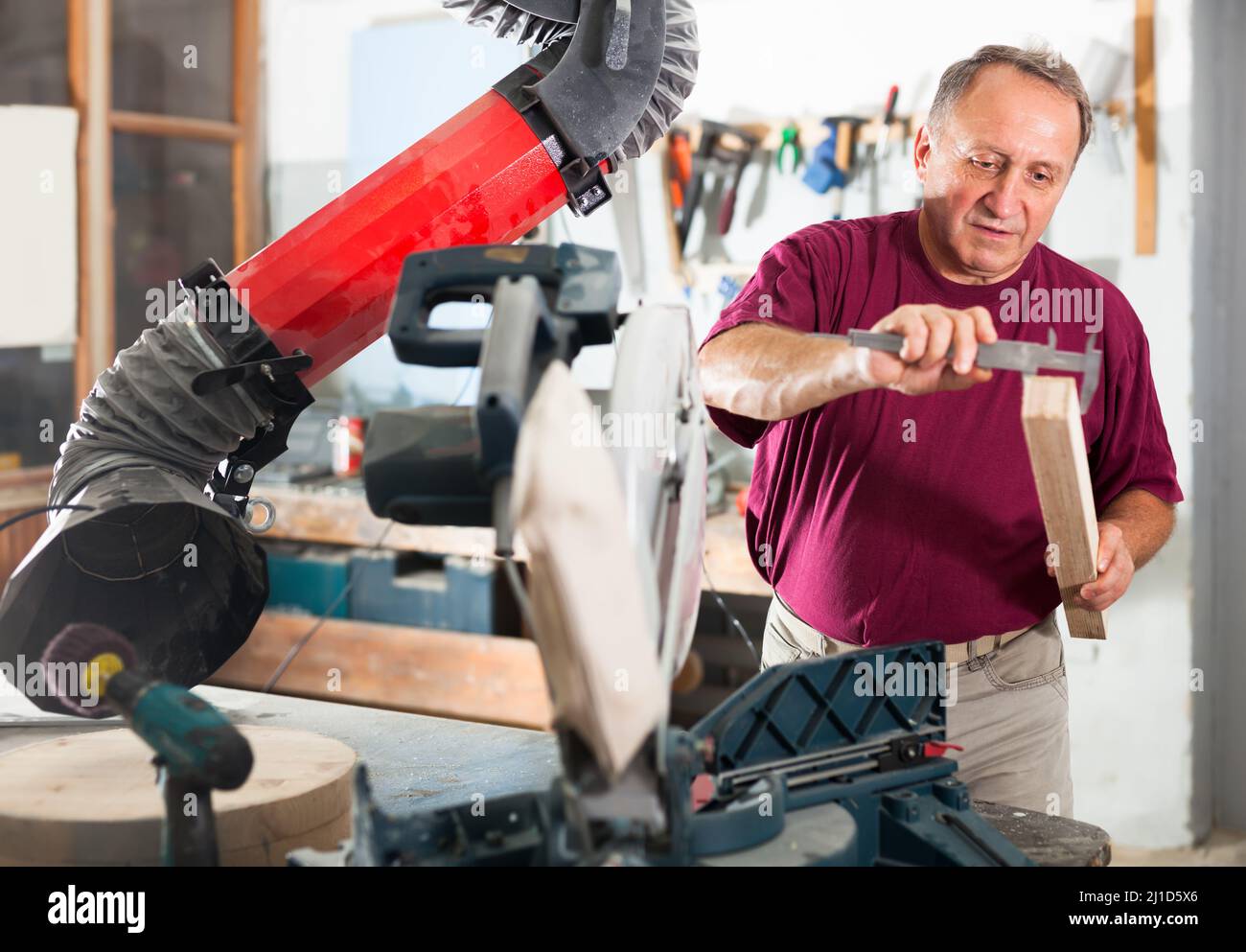 Worker performs measurements on wooden workpiece with caliper. Working with the measuring tool ...