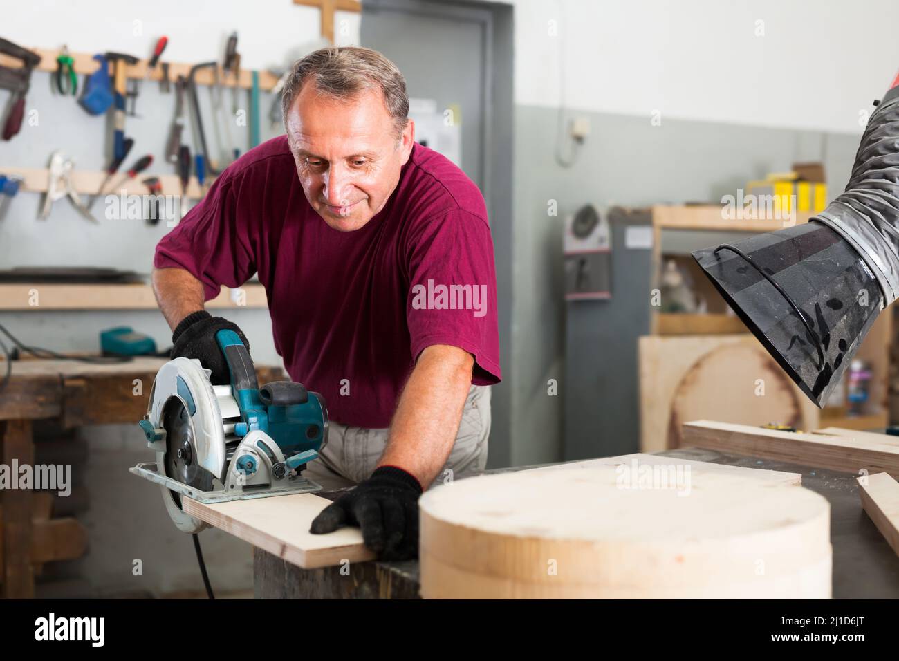 Worker cutting wooden workpiece on an hand electical circular saw Stock ...