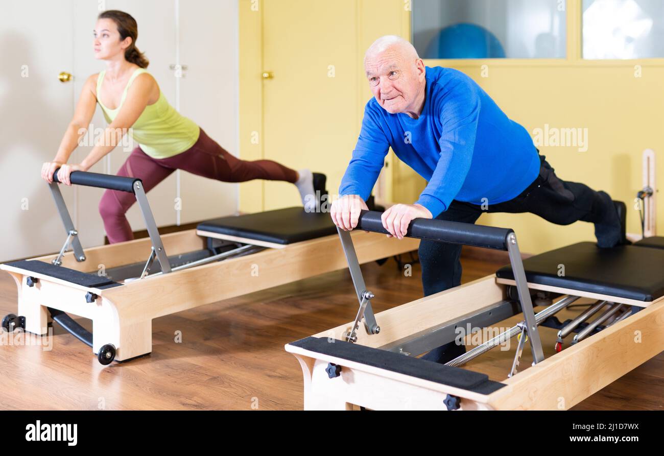Senior man doing stretching exercises on pilates reformer Stock Photo ...