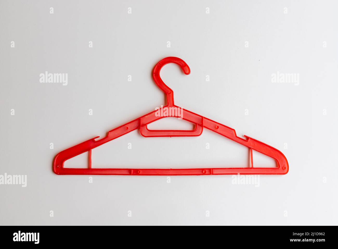 Red plastic hanger on white background Stock Photo - Alamy