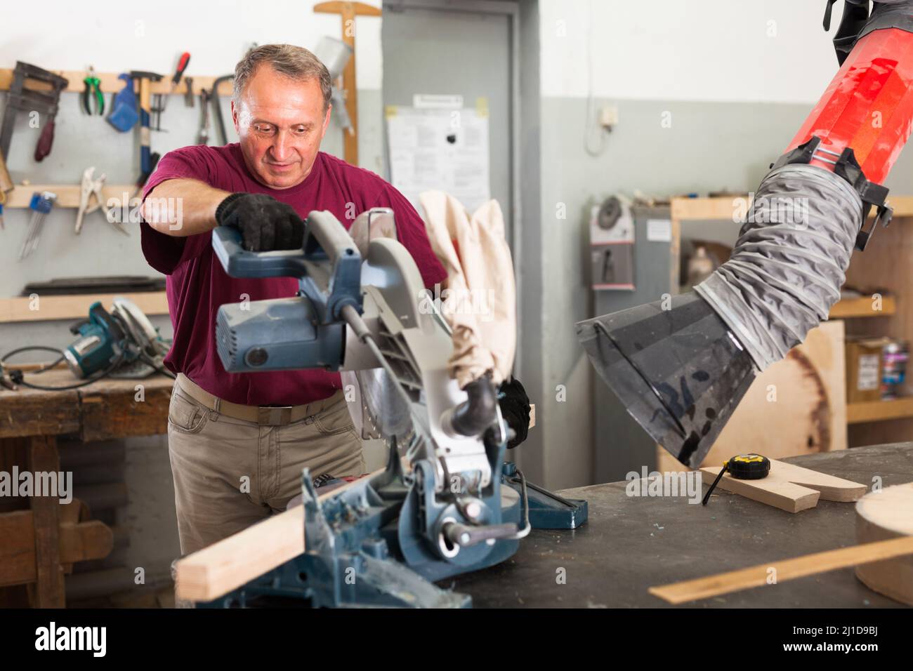Carpenter cutting a wooden workpiece on an electical circular saw Stock ...