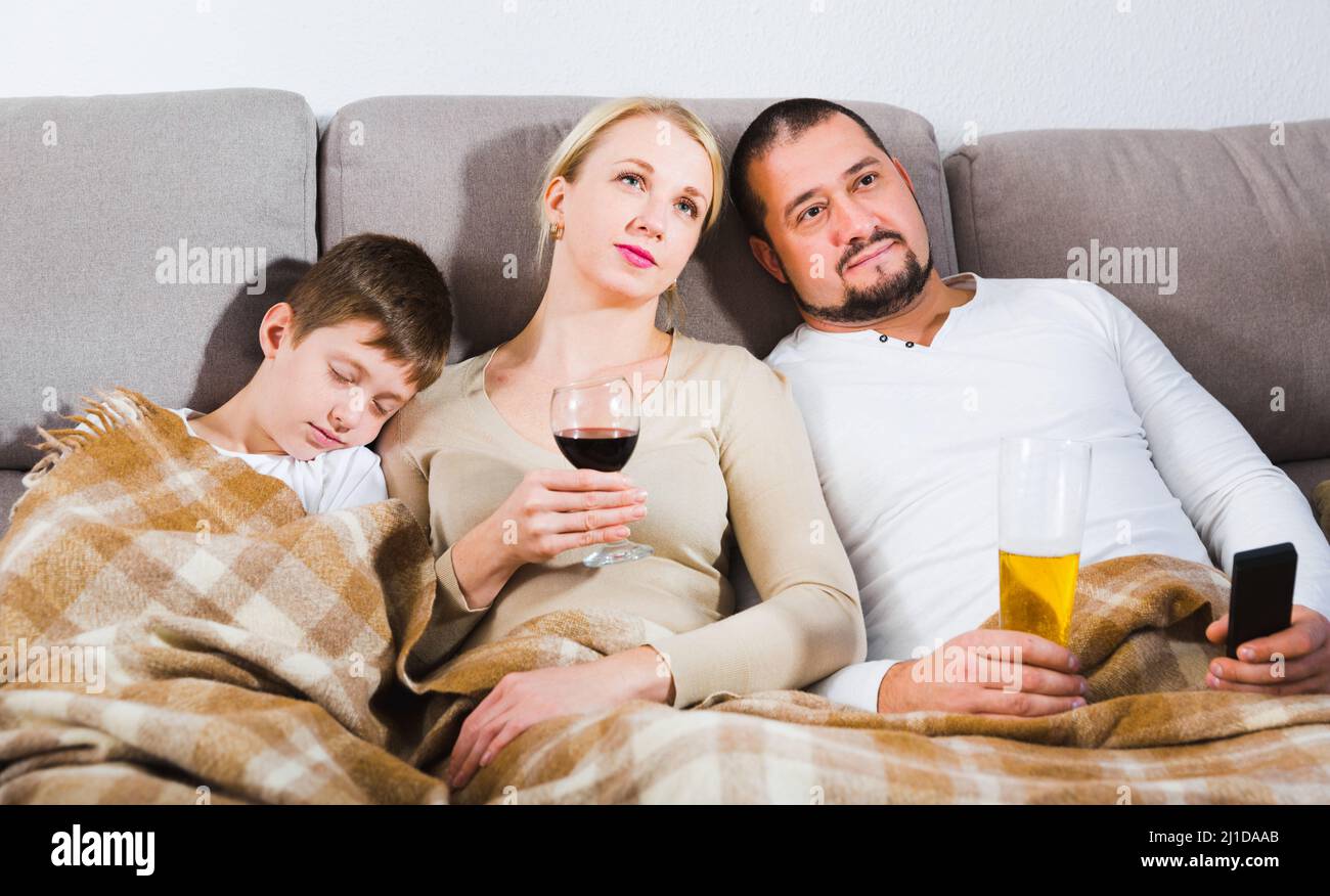 Happy parents with sleeping son watching TV Stock Photo - Alamy