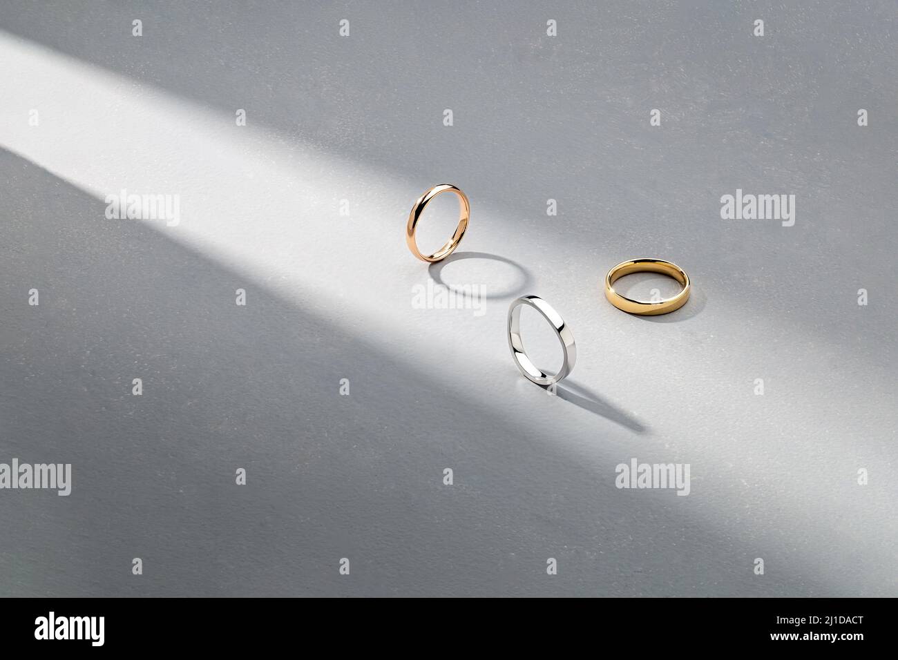 couple of wedding rings with simple design taken on gray background ...