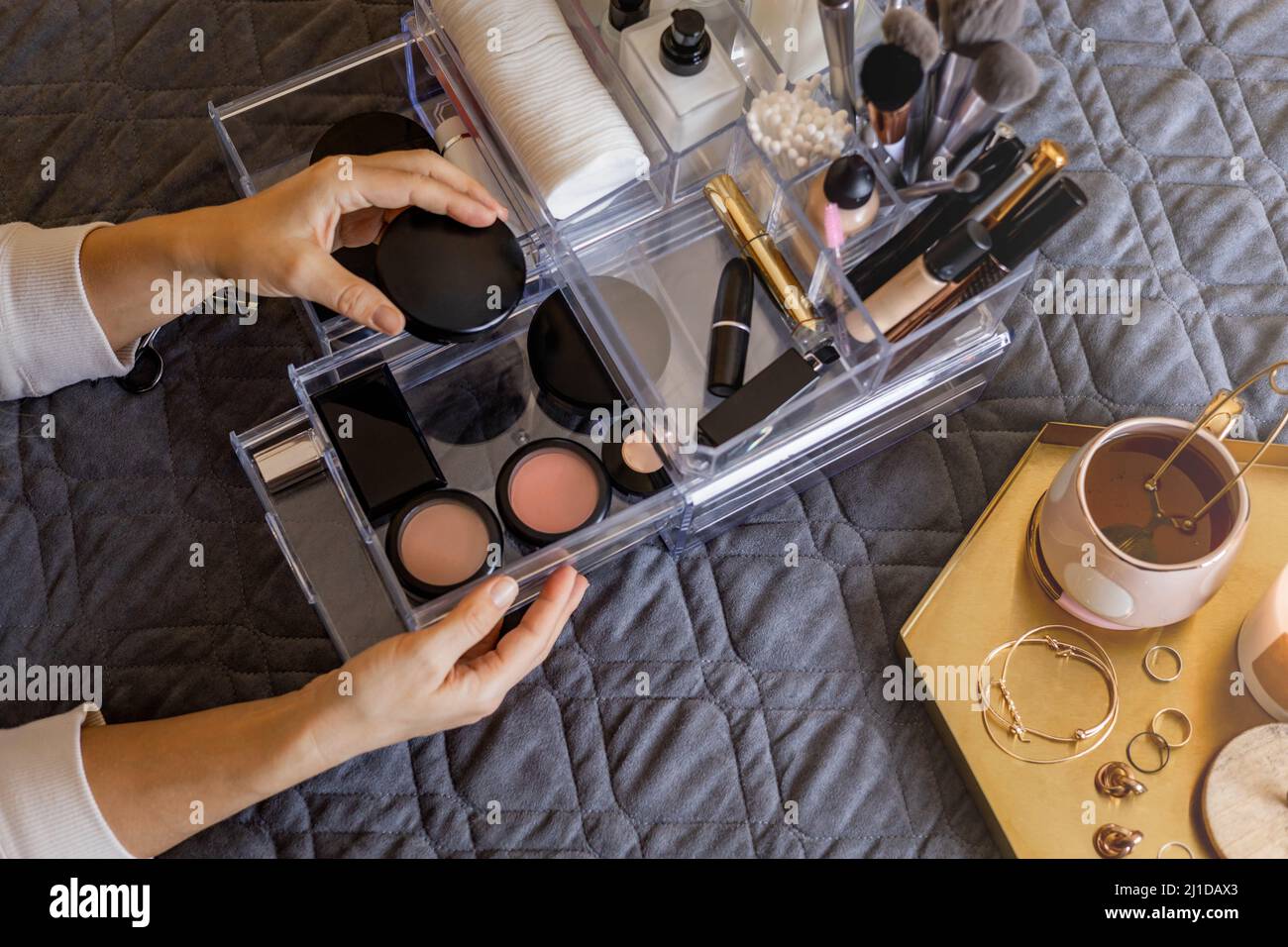 Woman hands tidying up putting powder container into acrylic storage ...