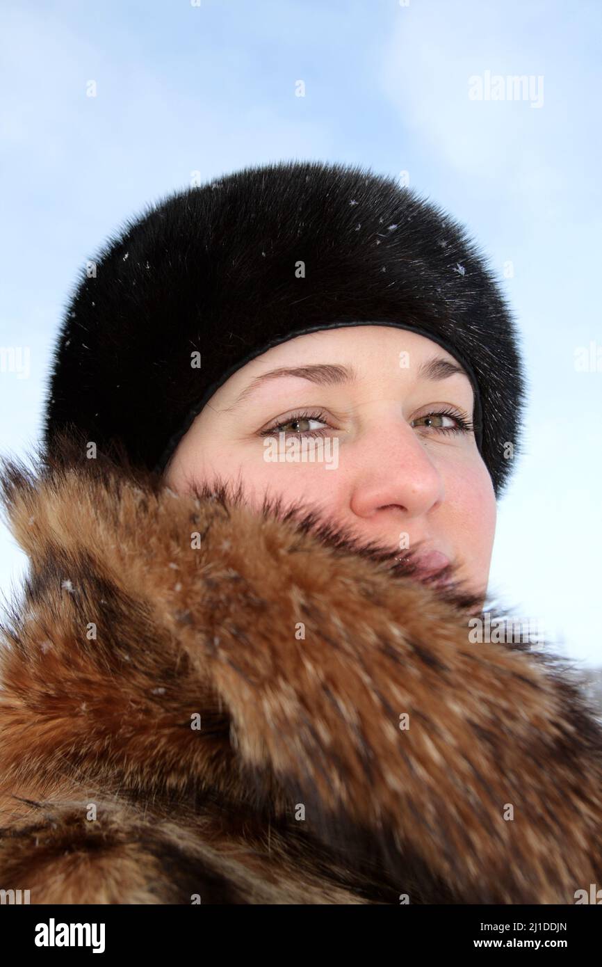 The girl in fur coat poses on the sky background Stock Photo - Alamy