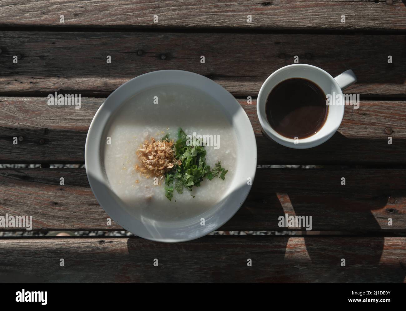 Pork congee or Rice porridge with minced pork sprinkled with deep-fried garlic and coriander in ...