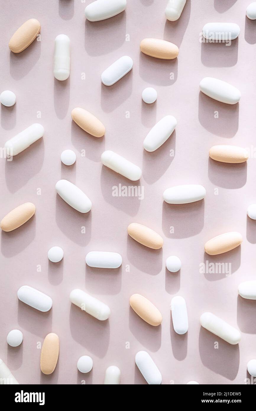 Different pills, vitamin capsules on pastel pink background. Dietary ...