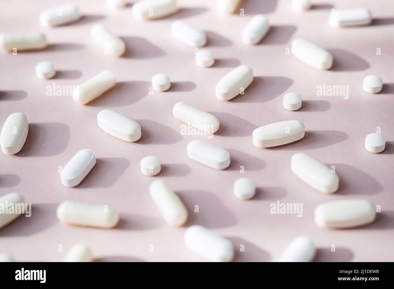 Different pills, vitamin capsules on pastel pink background. Dietary ...