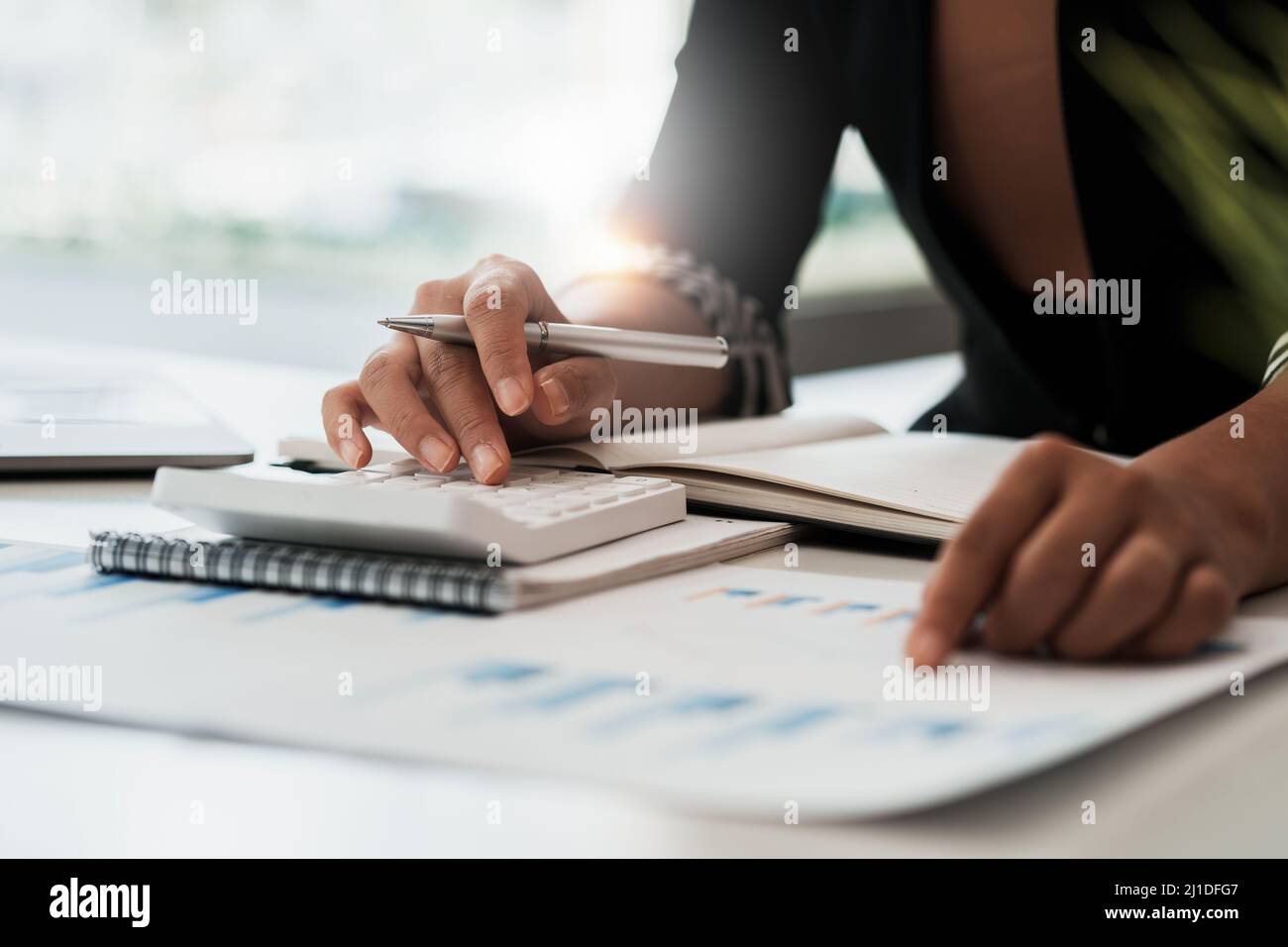 Business woman hand holding pencil and financial paperwork looking at ...