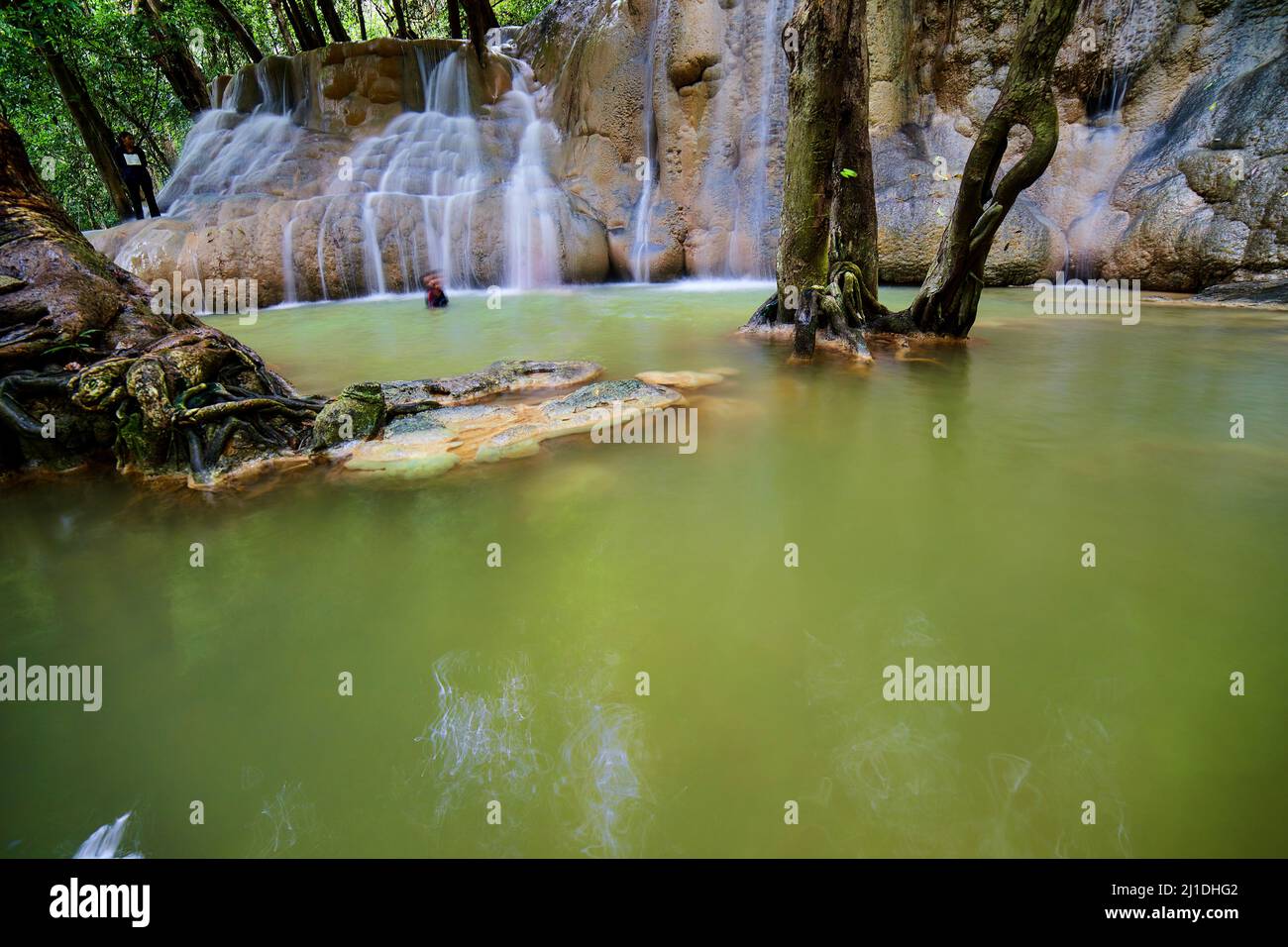 A beautiful waterfall with traveler in the forest Stock Photo - Alamy