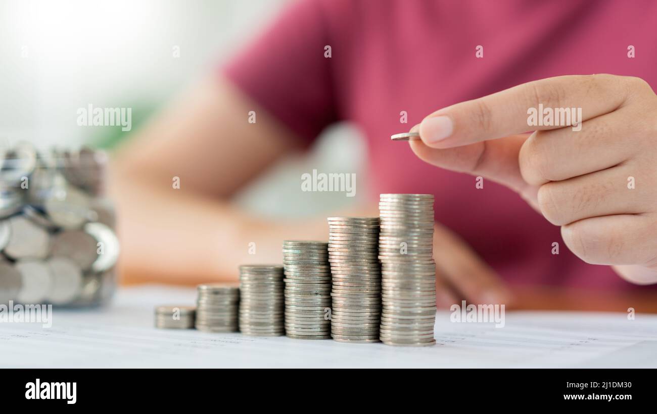 Saving concept the woman piling her coins to make the towers in ...