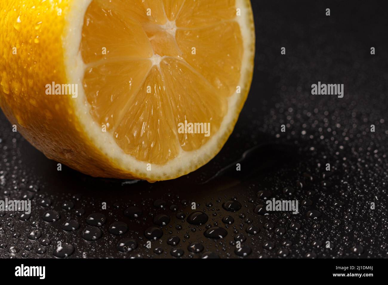 Fresh cut lemon on a black background Stock Photo - Alamy
