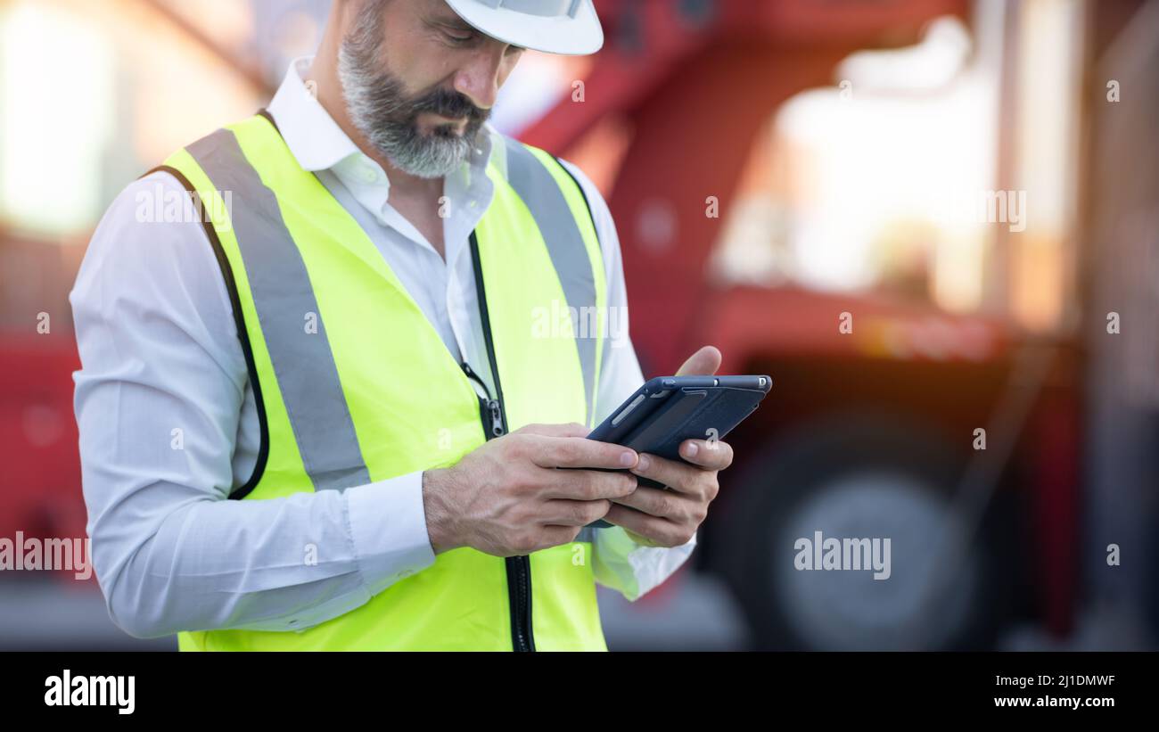 CEO or Manager in white helmet with tablet control loading Containers ...