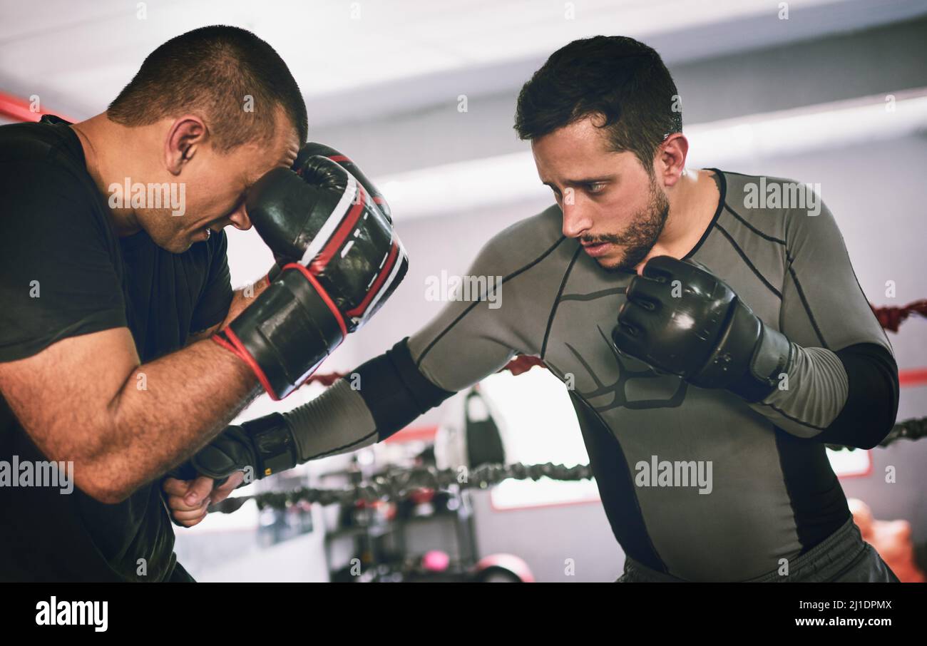 Put your hands up. Shot of two young male boxers facing each other in a ...