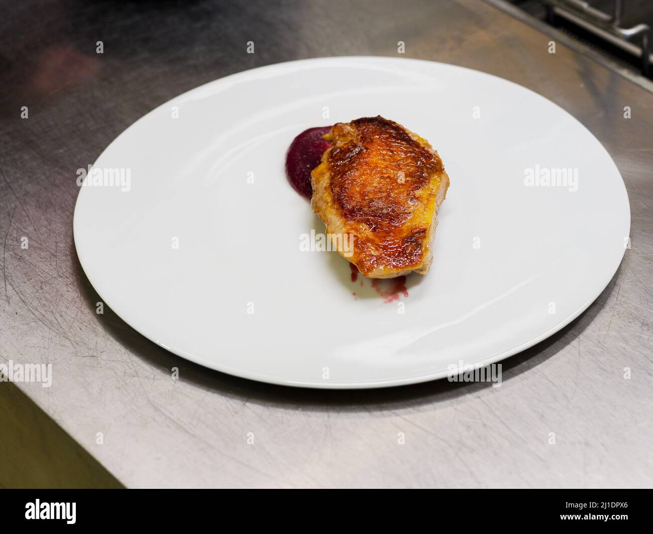 chef plating a main course with chiken and vegetables on a restaurant ...