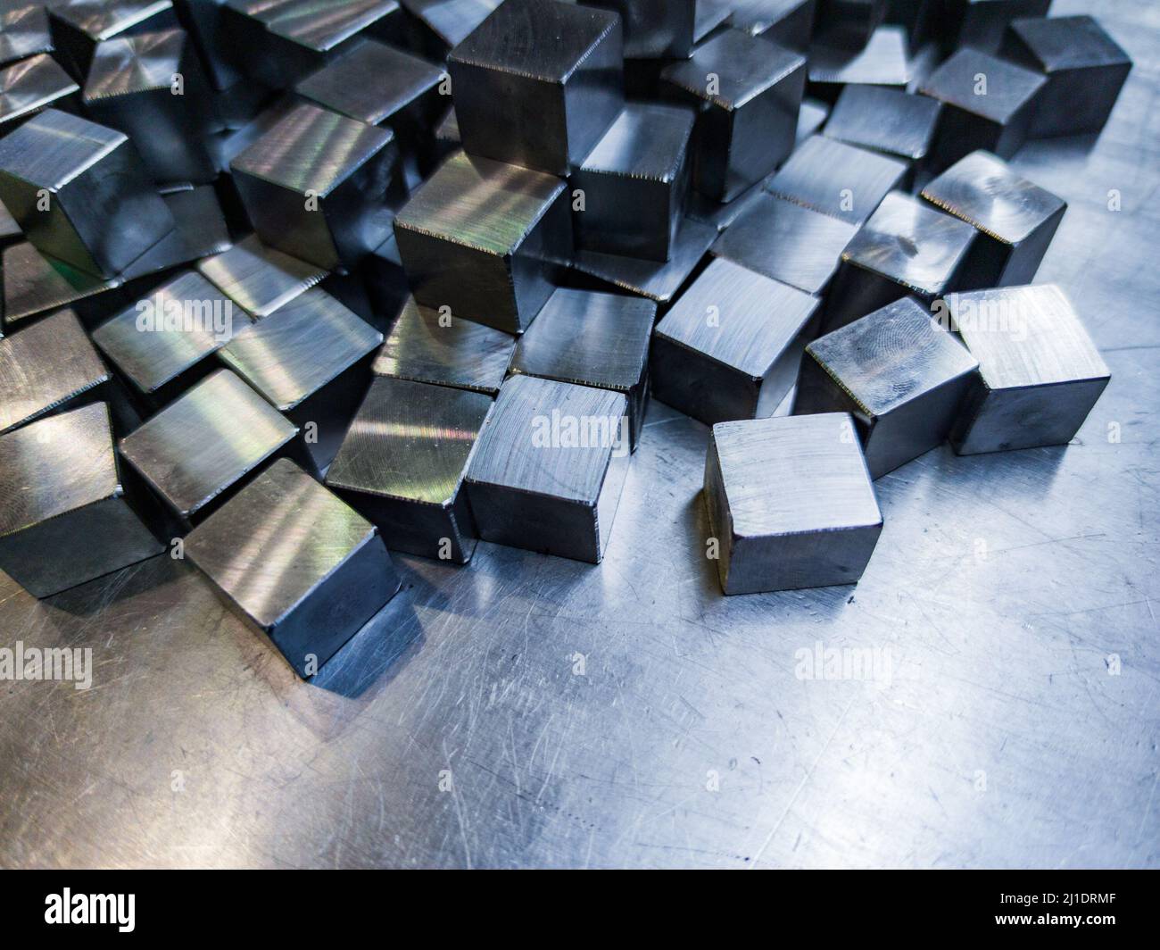 pile of small machined shiny steel cubes on metal surface Stock Photo ...
