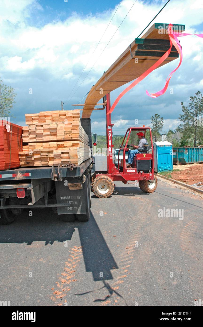 Delivering lumber by truck and fork lift the materials for wood framing ...