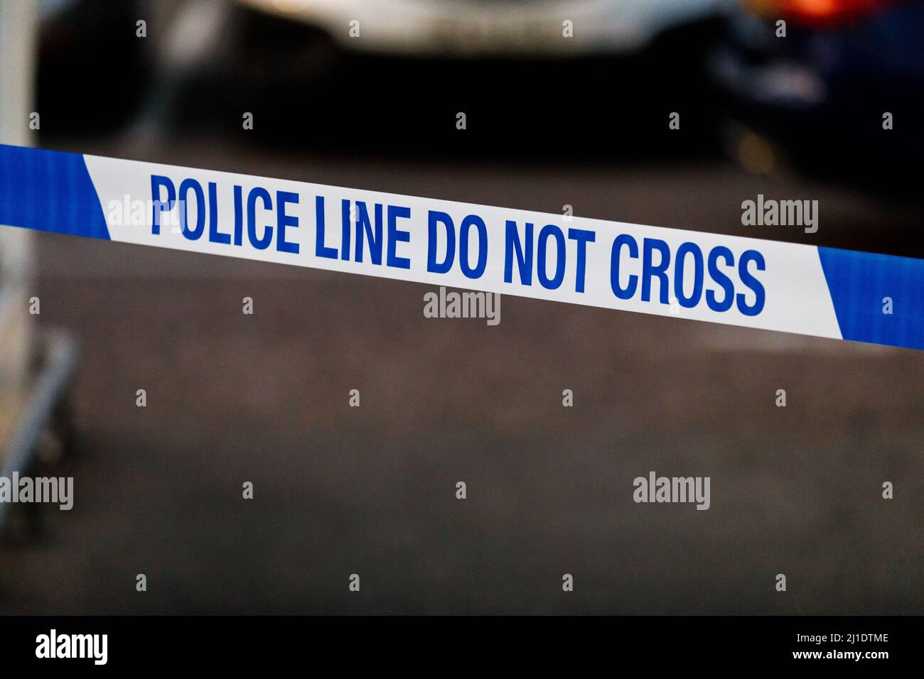 Blue and White POLICE LINE DO NOT CROSS cordon tape at the scene of a ...