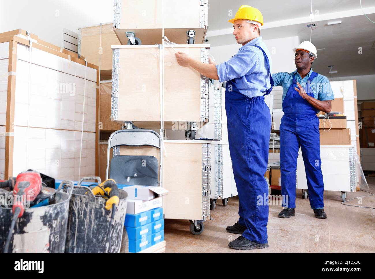 Two male builders working at indoors building site Stock Photo - Alamy