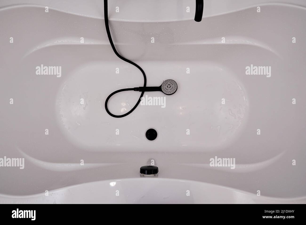 White acrylic bathtub with shower and faucet, top view. Bathroom and ...