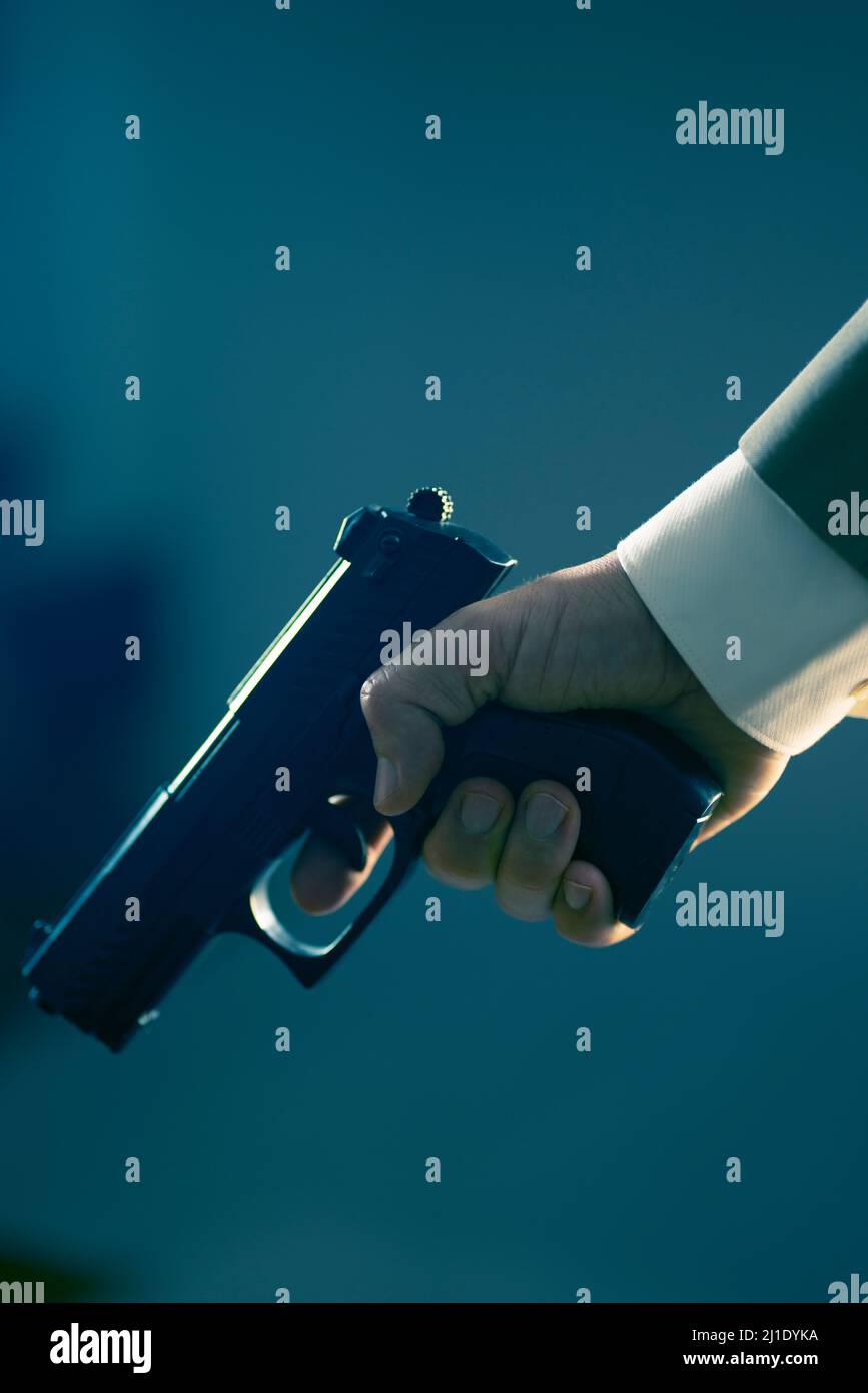 Male detective spy killer holding pistol gun in dramatic novel book ...