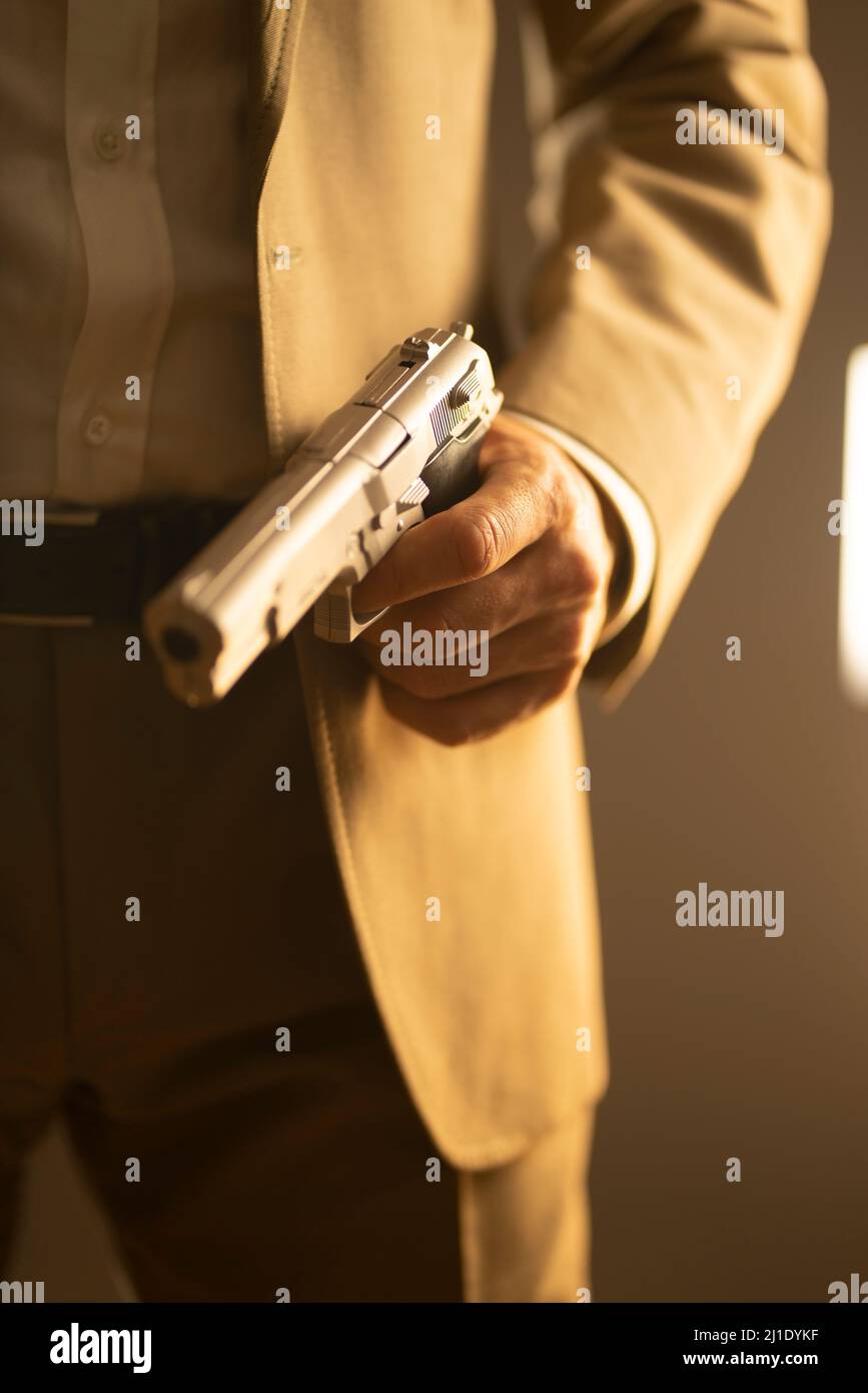 Male detective spy killer holding pistol gun in dramatic novel book ...