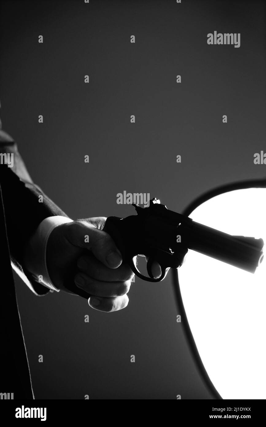 Retro secret agent with pistol revolver gun in hand in vintage crime ...