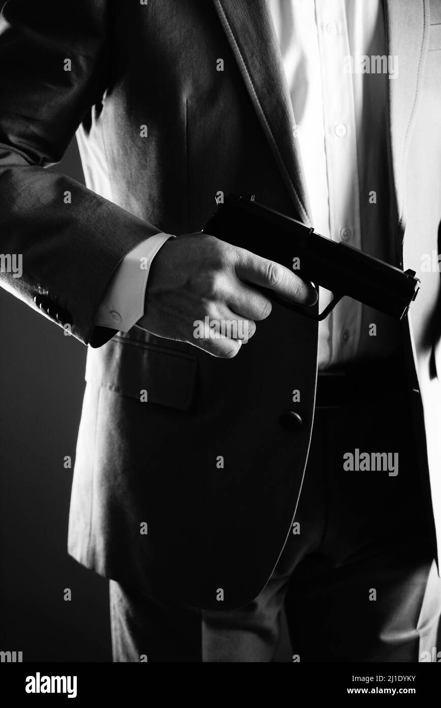 Retro secret agent with pistol revolver gun in hand in vintage crime ...