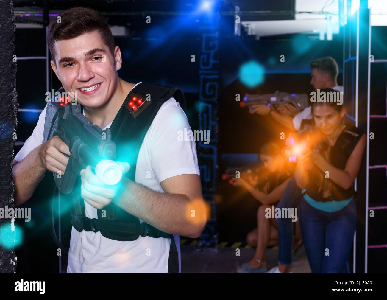 Excited guy holding laser pistol, playing laser tag with friends Stock ...