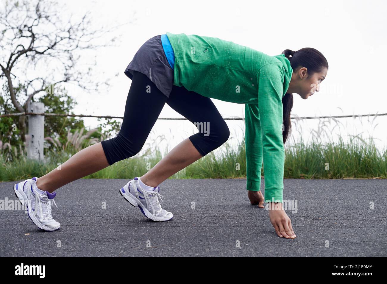 Ready to make this road her own.... A young woman crouching on the ...