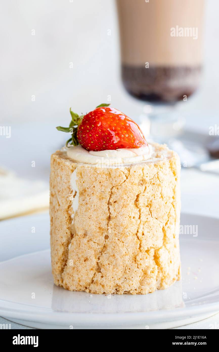 Strawberry log cake on a white background. With hot chocolate on the ...