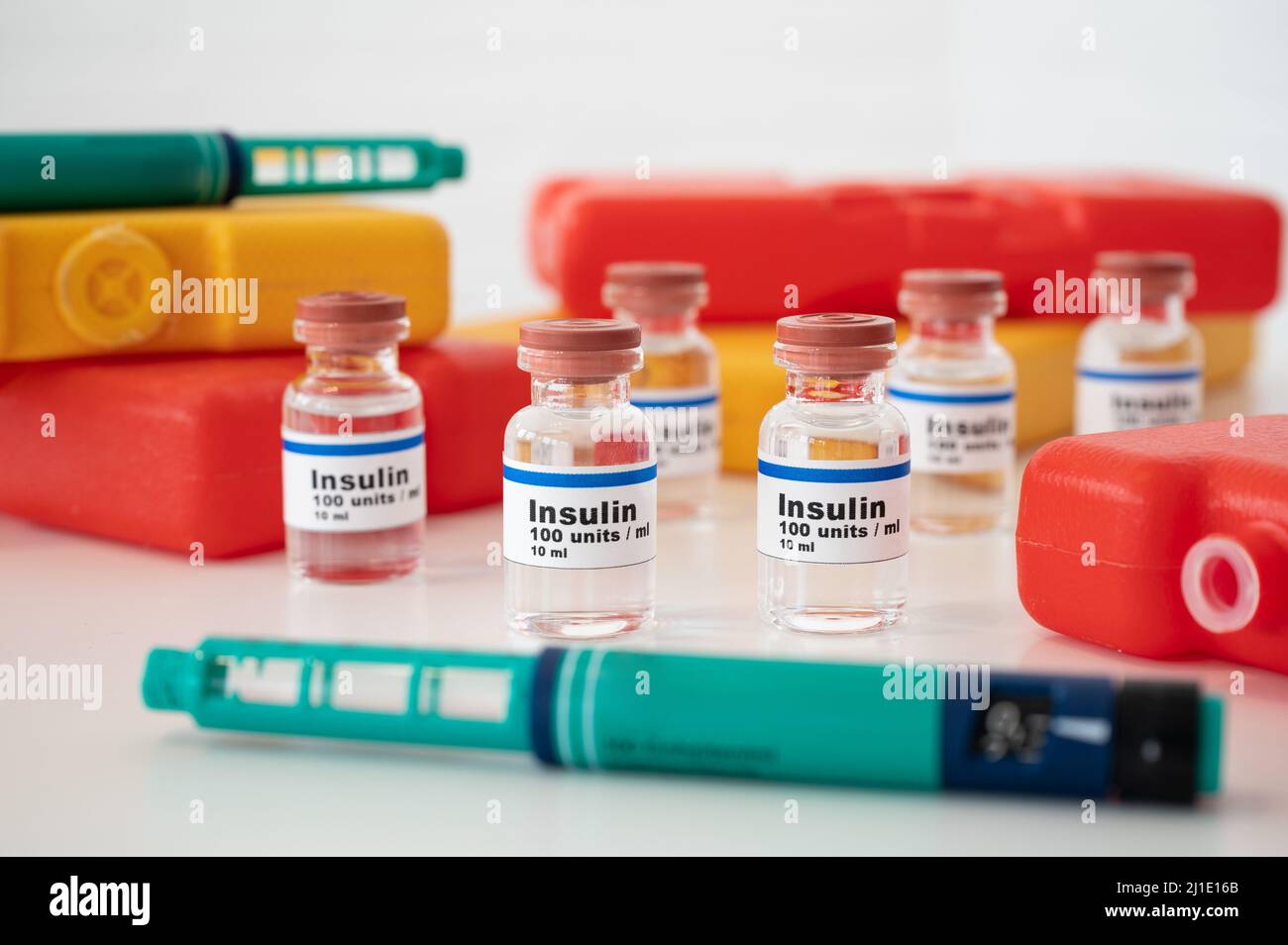 Insulin ampoules and insulin syringe with cold packs against a white ...