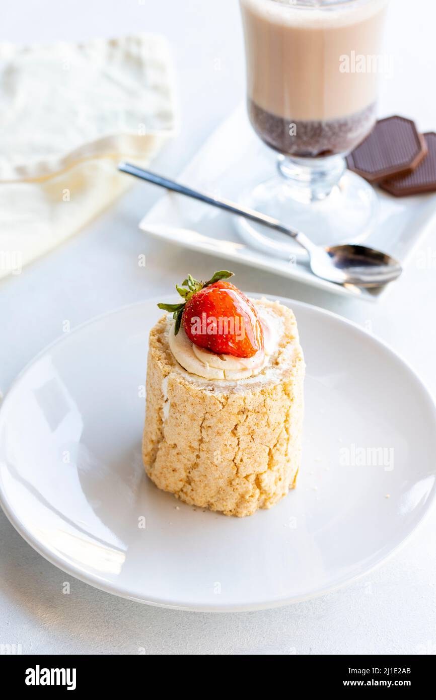 Strawberry log cake on a white background. With hot chocolate on the ...