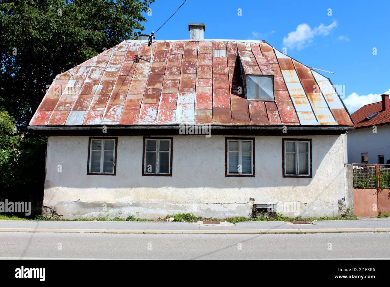 Front view of abandoned small urban family house on cracked stone and concrete foundation with ...