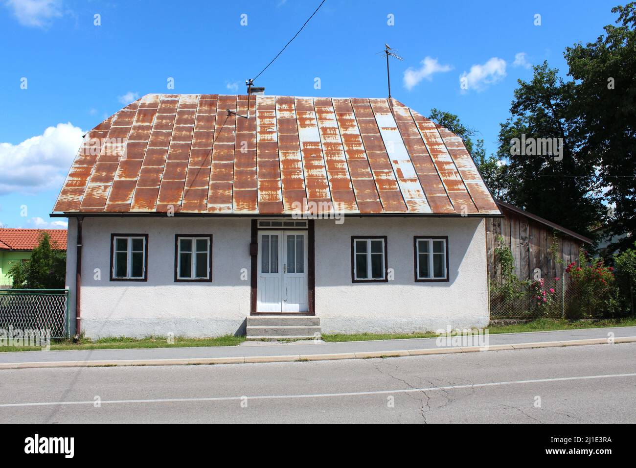 Front view of small urban family house with renovated facade and front double door entrance on ...