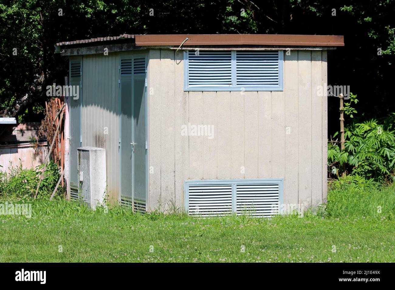 Local concrete electricity substation building with two grey metal ...