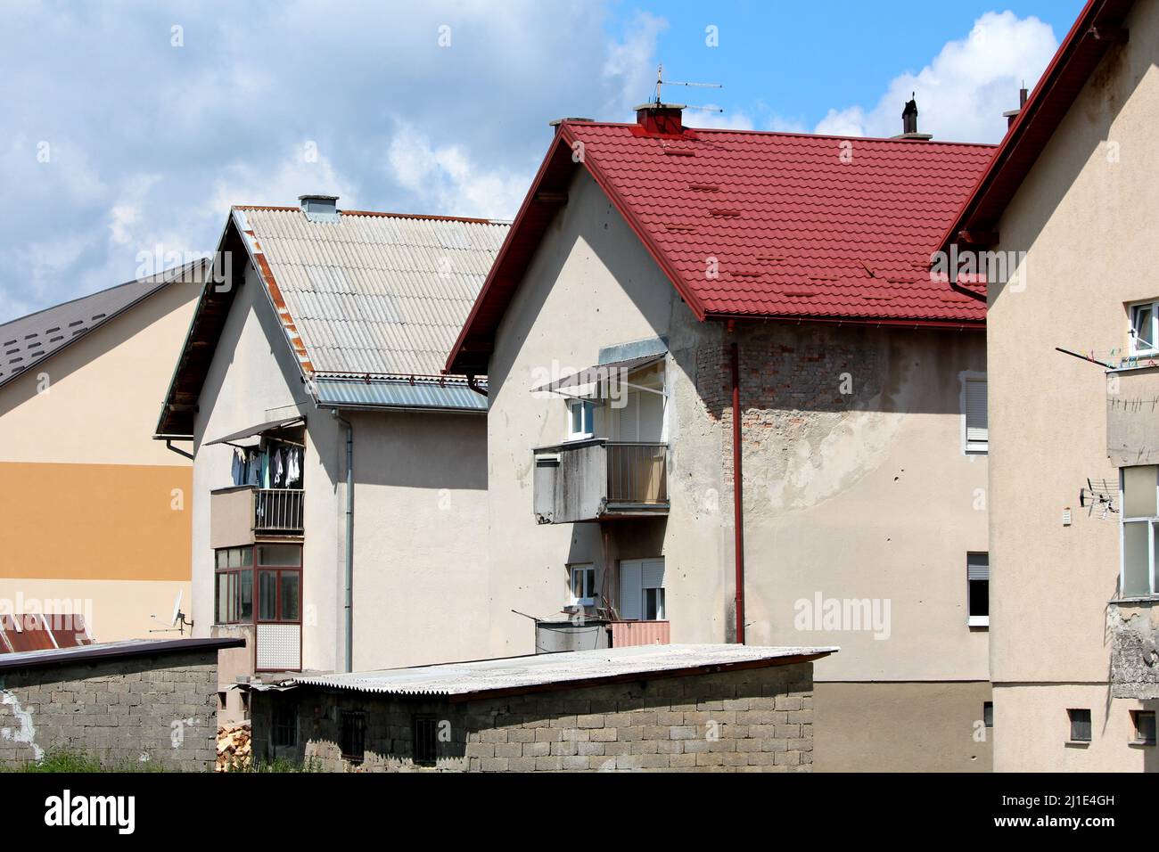Row of similar suburban family houses with old dilapidated facade and renovated roof with new ...