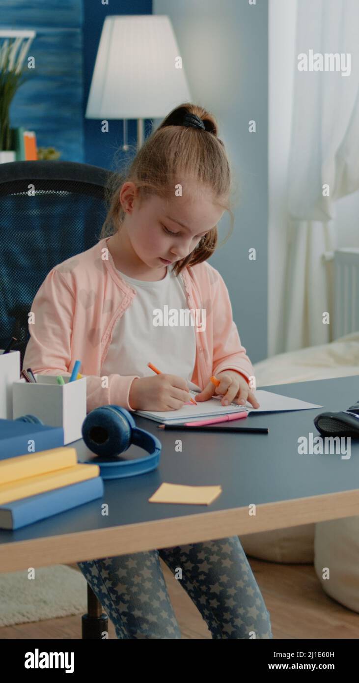 Little girl drawing on notebook with colorful pencils. Child enjoying ...