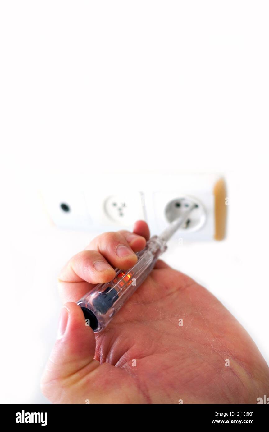 a master measuring the electricity in the socket with an electric control pen Stock Photo - Alamy