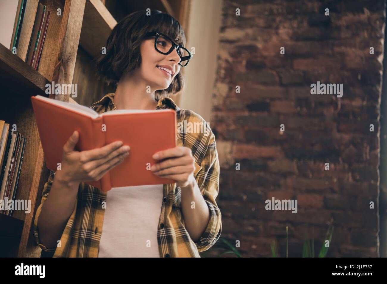 Portrait of charming cute lady in spectacles reading interesting novel ...