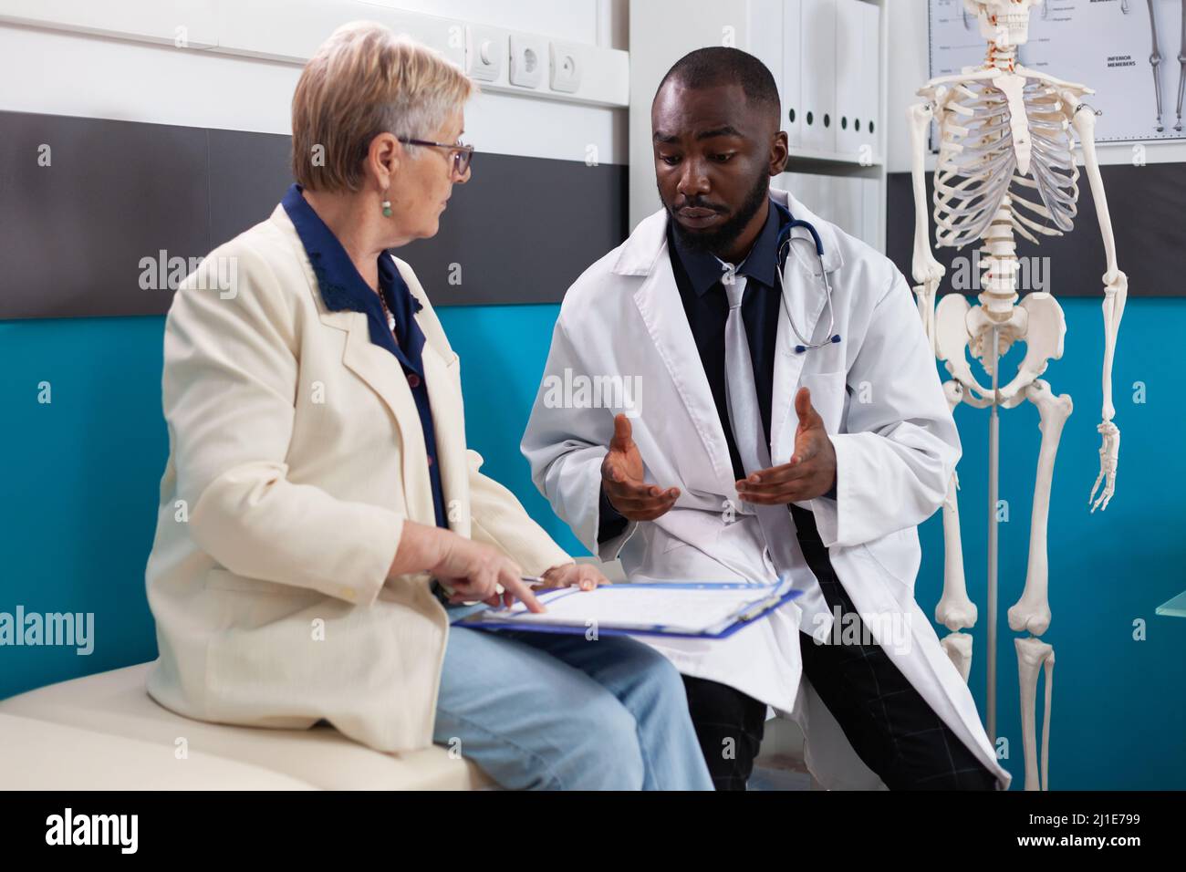 Senior woman patient signing medical documents while therapist doctor ...