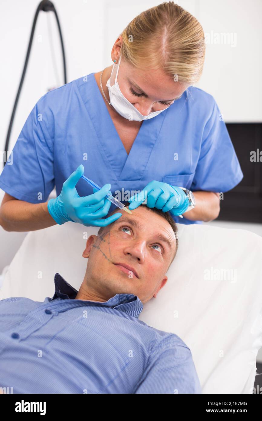 Female doctor is doing injection to patient in skin of face Stock Photo ...