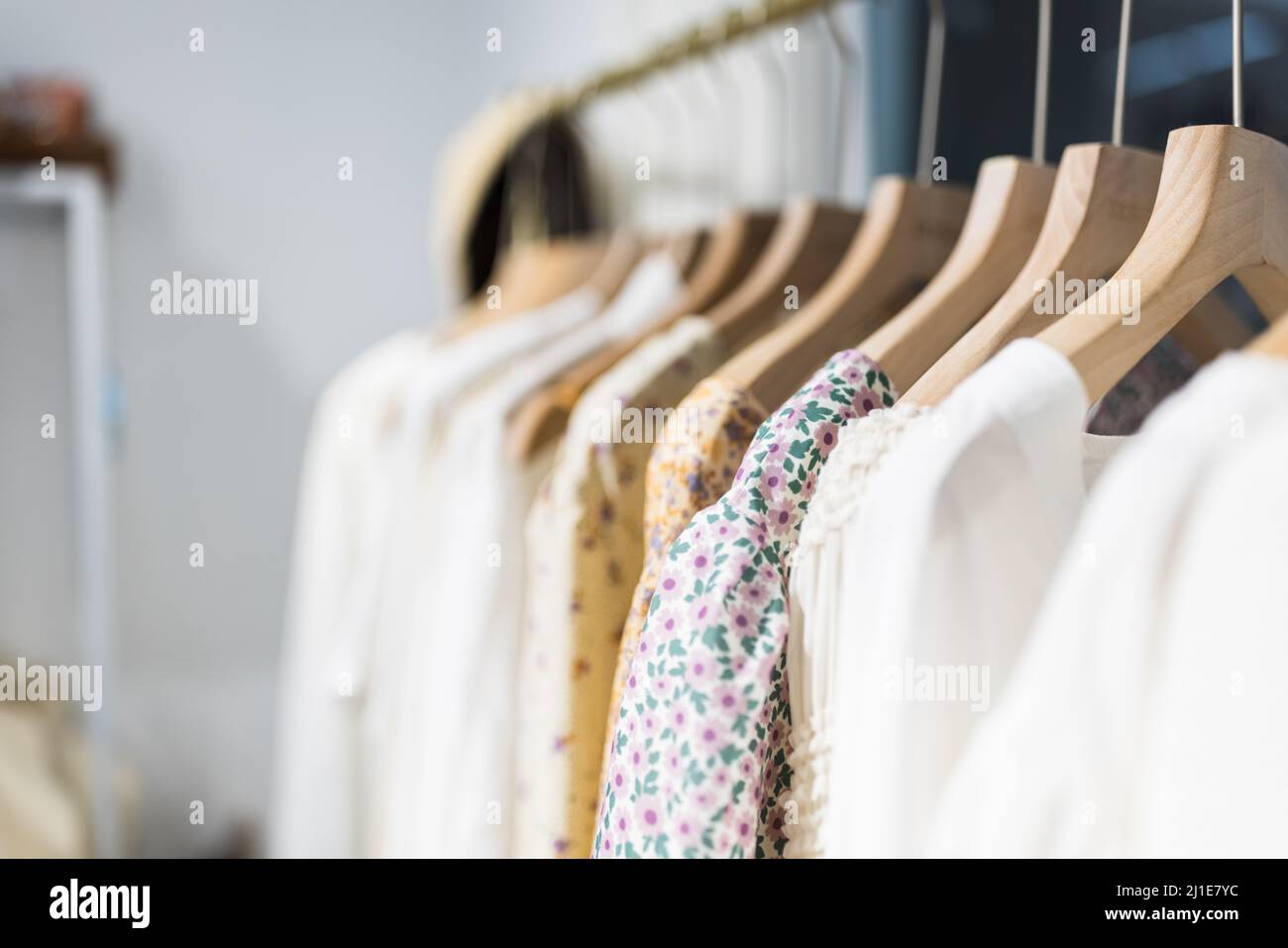 Row of different female clothes hanging on rack in hipster fashion show ...