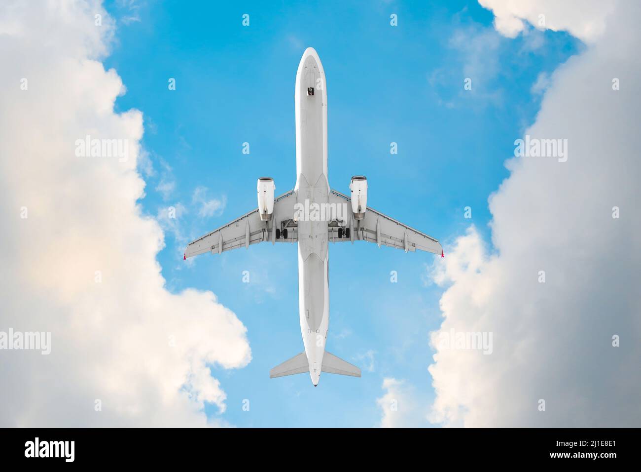 Airplane overhead flying against the background of beautiful clouds and ...