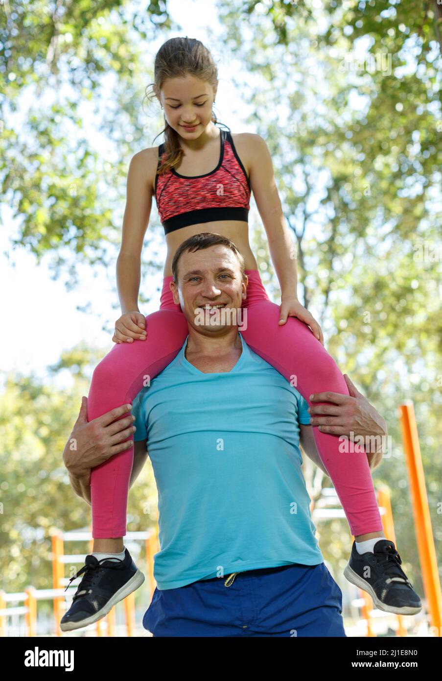 Girl sitting on shoulders of father Stock Photo - Alamy
