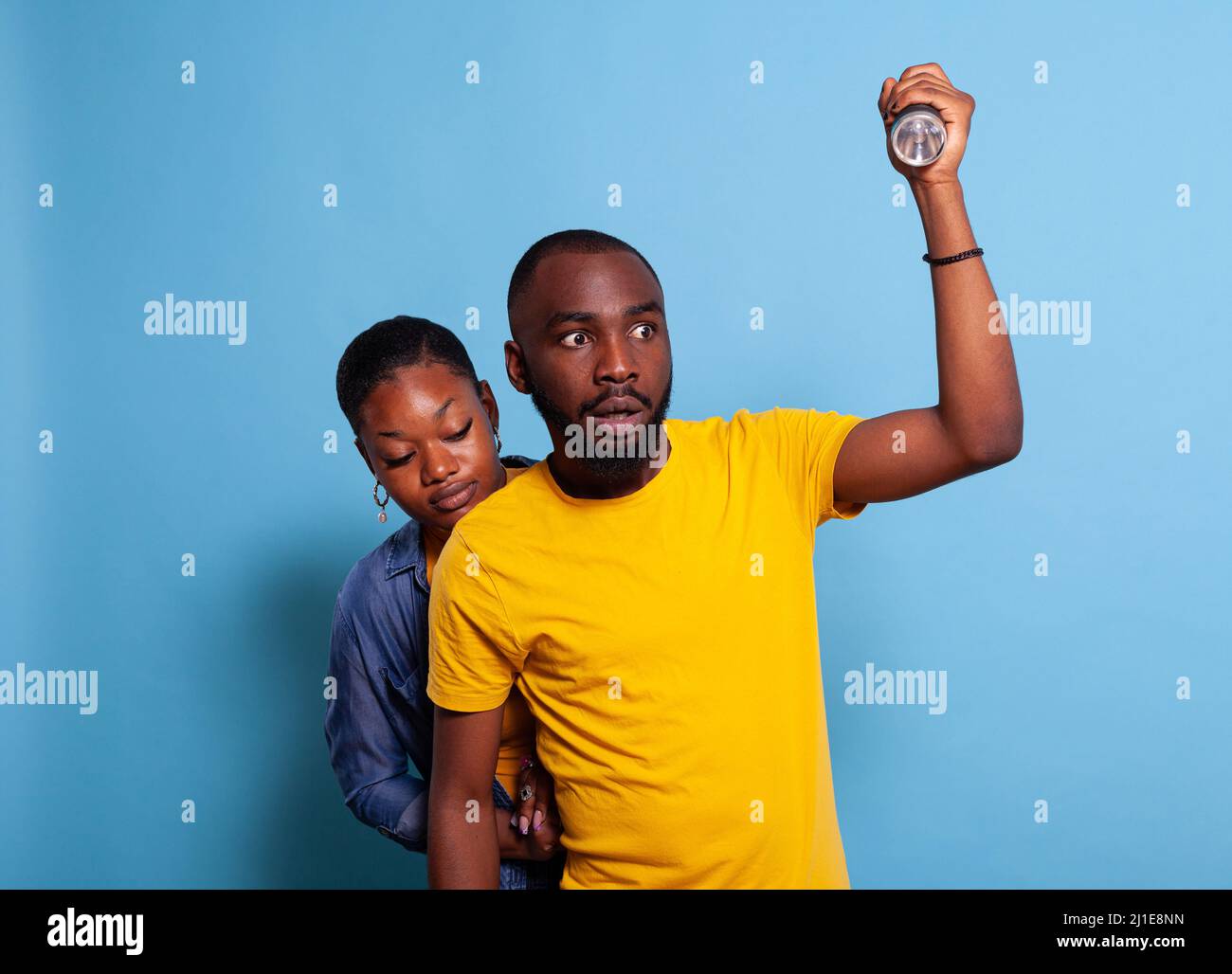 Frightened woman hiding behind man with flashlight, checking problem ...