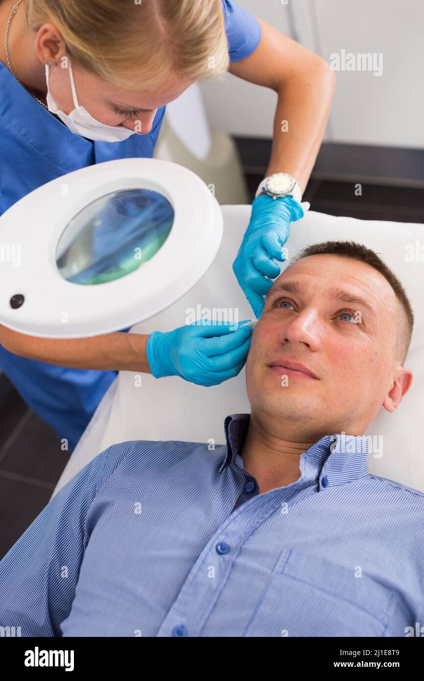 Female doctor is doing cleaning skin procedure to client Stock Photo ...