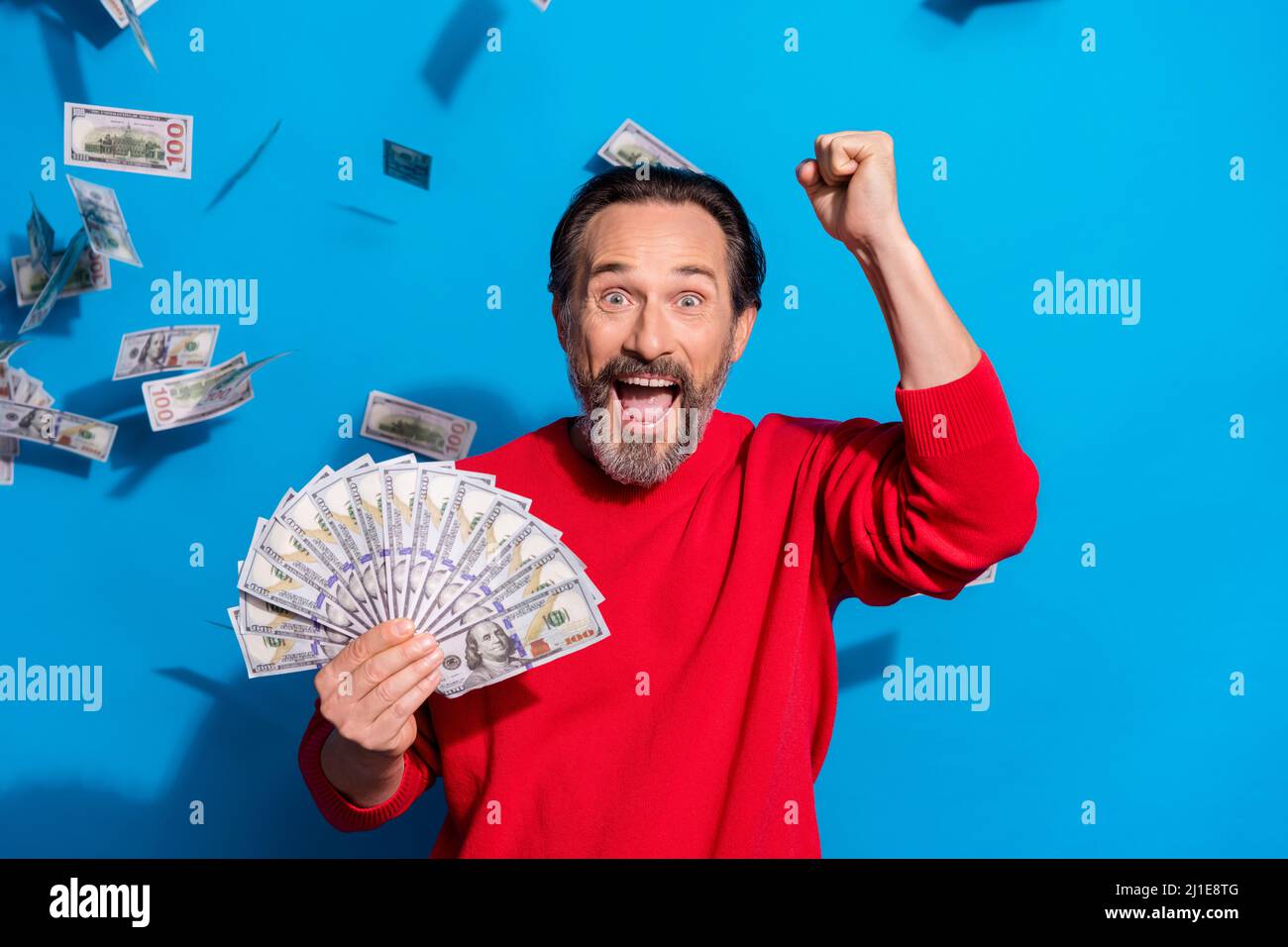 Portrait of attractive cheerful man holding cash flying credit loan ...